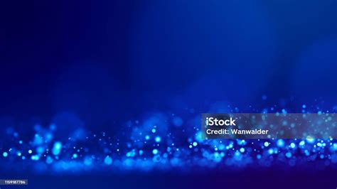 파란 배경에 빛나는 파란색 입자는 피사계 심도 및 가벼운 보케 효과와 밝은 축제 프리젠 테이션을 위해 공기에 매달려있습니다 버전 10 0명에 대한 스톡 사진 및 기타 이미지