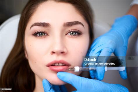 입술 확대 미용사 의사의 근접 촬영은 주사기와 여성 입술에 아름다움 절차를 하 고 젊은 여자의 입 수신 히 알루 론 산 주입 미용 치료 필러 치료 건강관리와 의술에 대한