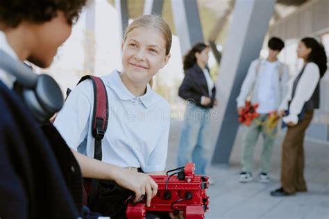 Smiling Blonde Girl Looking At Unrecognizable Classmate Stock Image