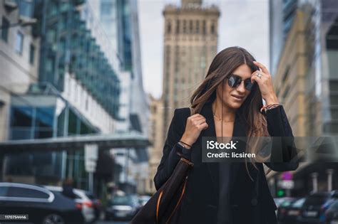 유럽의 도시에서 포즈를 취하는 젊은 예쁜 트렌디 한 소녀의 클로즈업 패션 여성 초상화 거리에서 걷는 선글라스를 입은 아름다운 세련된 여성 가방에 대한 스톡 사진 및 기타