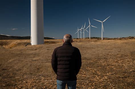 푸른 하늘을 배경으로 현대 풍차와 땅에서 겨울 천에 성인 남자 스페인 카스티야 라 만차에서 촬영 풍력발전기에 대한 스톡 사진 및
