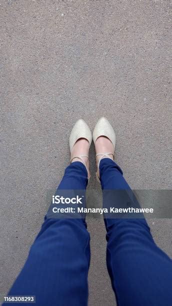 발과 다리는 위에서 볼 수 있습니다 거리 도로 배경에 파란색 바지와 골드 하이힐 신발을 입고 셀카 여자 맨 위 보기 가냘픈에