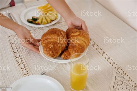 크루아상이 있는 흰색 접시를 들고 테이블을 세우는 여성의 클로즈업 테이블에 오렌지 주스와 과일과 유리조각 아침 식사 30 39세에 대한 스톡 사진 및 기타 이미지 Istock