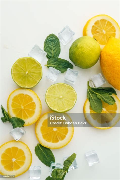 신선한 라임과 레몬 반쪽 흰색 배경에 민트 잎과 얼음 조각 감귤류 과일을 선보이는 생동감 넘치는 구성으로 건강한 음식 음료 또는 여름 테마에 적합합니다 각얼음에 대한 스톡