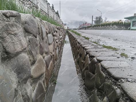 Premium Photo Decorative Drain Ditch With Walls Lined With Stone