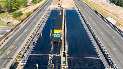 고속도로 건설 현장의 항공 영상으로 대형 아스팔트 부설 기계와 작업자가 등장합니다 0명에 대한 스톡 사진 및 기타 이미지 0