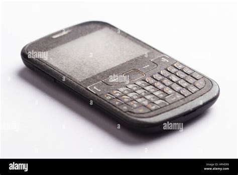 Side View Close Up Of Old Black Smartphone Mobile With Qwerty Keyboard Covered In Dust And
