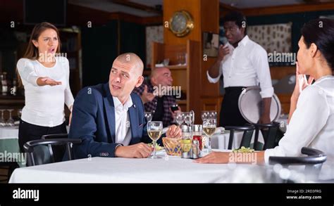 Wife Scolding Husband Spending Time With Another Woman In Restaurant