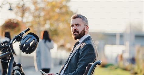 스마트폰과 자전거를 들고 출퇴근하는 사업가가 도시의 벤치에 앉아 있는 모습 사진 Unsplash의 자전거 이미지