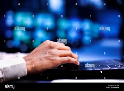 close up shot of employee in server farm using laptop to set up