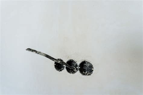 이 이미지는 밝은 흰색 표면에 위치한 세 개의 검은색 원을 자세히 클로즈업하여 어두운 색상과 밝은 색상 사이의 눈에 띄는 시각적 대비를 만듭니다 0명에 대한 스톡 사진 및