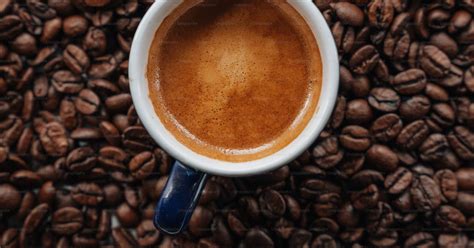 커피 원두 더미 위에 앉아있는 커피 한 잔 사진 Unsplash의 커피 콩 이미지