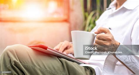 커피잔을 들고 태블릿을 사용하는 전문직 사업가가 현대적이고 생산적인 작업 환경을 보여줍니다 기술 캐주얼 비즈니스 회의 또는 사무실 생활과 관련된 개념에 적합합니다 45 49