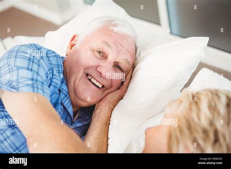 Portrait Of Happy Man Lying With Wife On Bed Stock Photo Alamy