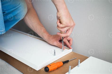 Close Up Of Man Hand Furniture Assembler Make Flat Pack White Furniture Assembly Service At
