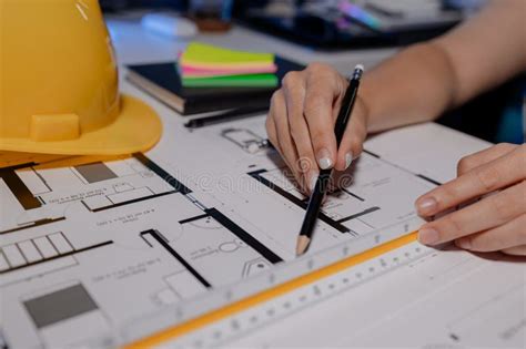 An Engineer Is Working In A Private Office With Documents Spread Across