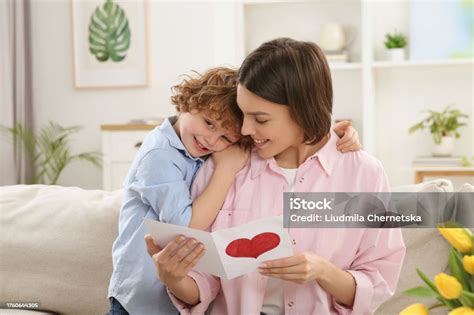 집에서 어머니의 날을 축하하는 어린 아들 손수 만든 인사말 카드를 들고 여자 어머니에 대한 스톡 사진 및 기타 이미지 어머니 인사장 놀라움 Istock