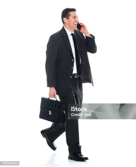백인 젊은 남성 매니저는 비즈니스 웨어를 입고 서류 가방을 들고 스마트 폰을 사용하여 흰색 배경 앞에서 걷고 있습니다 35 39