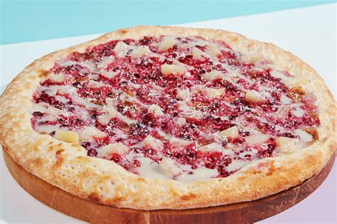 색깔이있는 배경에 과일과 열매가있는 이탈리아 피자 바나나 베리 및 소스를 파란색으로 최소한의 스타일로 곁들인 달콤한 피자 색상 배경을 가진 미국 피자 배달 개념 과일에 대한