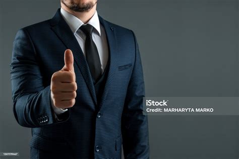 양복을 입은 남성 핸드는 회색 배경에 엄지 손가락을 위로 제스처를 보여줍니다 개념 확인 승인 클로즈업 30 34세에 대한 스톡