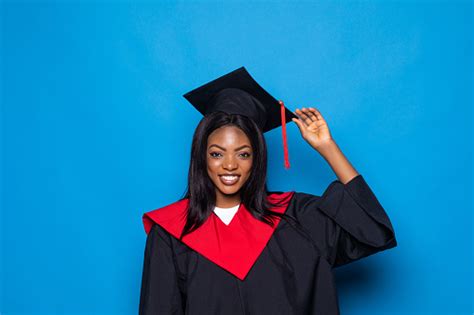 졸업장을 들고 파란색 졸업 가운을 입고 아름다운 아프리카 여성은 파란색 배경에 고립 되어 매우 행복하고 흥분 교육에 대한 스톡 사진 및 기타 이미지 Istock