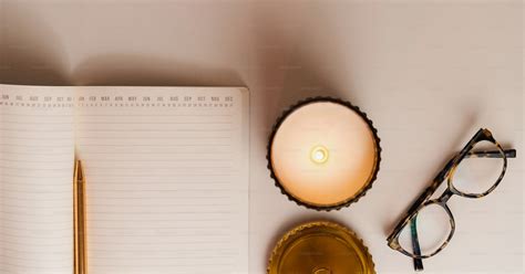 A Desk With A Notebook Pen Eyeglasses And A Candle Photo Candle Image On Unsplash