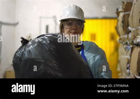 Serious Woman With Garbage Bag Walking On Recycling Station As Live