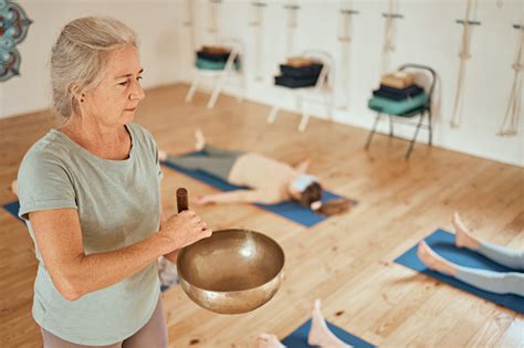 명상 수업 및 체육관 스튜디오에서 고요함 평화 및 선을위한 티베트 노래 그릇을 가진 여성 영적 치유 마음 챙김 및 요가 운동 및 필라테스 수업의 수석 피트니스 코치 웰빙