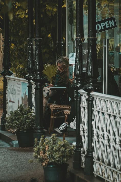 갈색 나무 의자에 앉아 흑백 드레스를 입은 여자 사진 Unsplash의 무료 영국 이미지