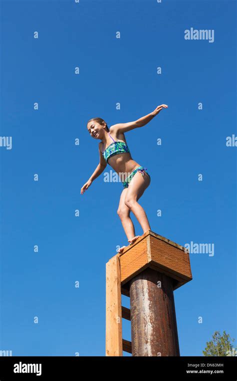 Mixed Race Girl Jumping Off Platform Stock Photo Alamy