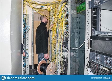 The Man Puts The Cable In The Server Room The Technician Works In The Datacenter The Network
