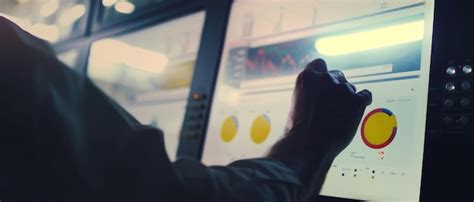 A Person Barely Visible Interacts With Data Visuals On Glowing Computer