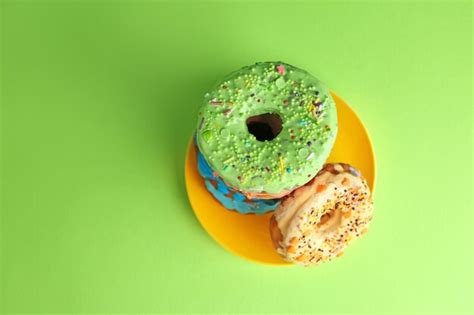 Premium Photo Plate With Colorful Donuts On Green Background