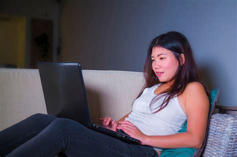젊은 아름 다운 아시아 한국 학생 여자 행복 하 고 편안한 가정에서 소파 소파 노트북 컴퓨터 네트워킹 온라인 기술 통신 라이프 스타일 개념에 밝은 인터넷을 사용 하 여 30