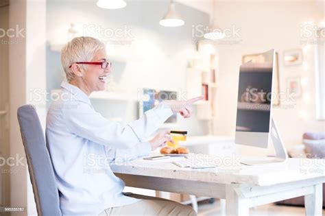 아름 다운 노인 여성 신용 카드를 보유 하 고 그녀의 손에 계산 옆 경기 스포츠에 대한 스톡 사진 및 기타 이미지 경기 스포츠 노인 컴퓨터 Istock