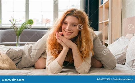 Smiling Happy Flirting Woman Peeking Out From Under Blanket In Bed At Home Kissing At Camera