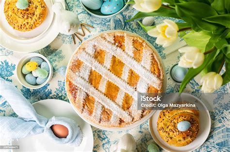 바로 위에 있는 브런치를 위한 부활절 테이블이 제공됩니다 이탈리아 부활절 케이크 리코타 치즈를 곁들인 쇼트 크러스트 파이 파스티에라 나폴레타나 다채로운 달걀 롤빵 새 조각품