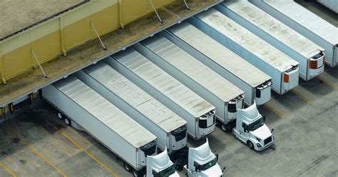 추가 소매 배송을 위해 소매 제품을 하역하고 업로드하는 많은 화물 세미 트럭이 있는 대기업 배송 센터 글로벌 시장 개념입니다 사진 Unsplash의 제공 이미지