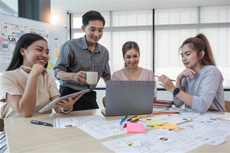 Group Of Asian Ux Developer And Ui Designer Serious Brainstorming About Mobile App Interface On