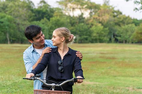 라이프 스타일 로맨틱 한 연인 개념 자전거를 밀고 있는 활동적인 젊은 부부는 함께 휴가를 보내며 팩에 담긴 이야기를 나누며