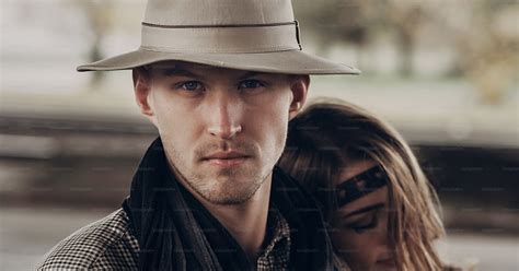 세련된 셔츠에 흰 모자와 검은 스카프를 두른 잘생긴 카우보이 남자가 아름다운 인디 여성에게 안겨 매혹적인 표정을 짓고 있다 사진 Unsplash의 스카프 이미지