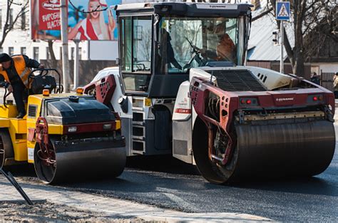 무거운 진동 롤러 압축기를 가진 무거운 아스팔트 도로 롤러는 거리의 도로 건설 현장에서 도로에 새로운 뜨거운 아스팔트를 누릅니다 거리에 대한 스톡 사진 및 기타 이미지