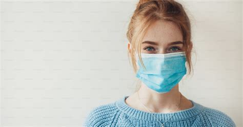 주근깨가 있는 빨간 머리 백인 여성은 의료용 마스크를 쓰고 여유 공간이 있는 흰색 스튜디오 벽에 카메라를 보고 있다 사진 Unsplash의 몰도바 이미지