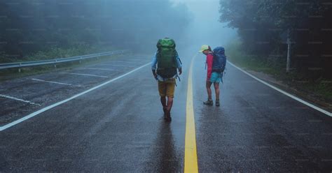 연인 아시아 남성과 아시아 여성은 자연을 여행합니다 도로 경로를 걸어보세요 자연을 즐겁게 여행합니다 안개 속에서 비가 내린다 장마철에 사진 Unsplash의