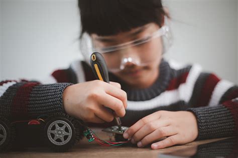 아시아 학생들은 집에서 Stem Steam 수학 공학 과학 기술 컴퓨터 코드 아이들을위한 로봇 공학 개념의 로봇 자동차 및 전자