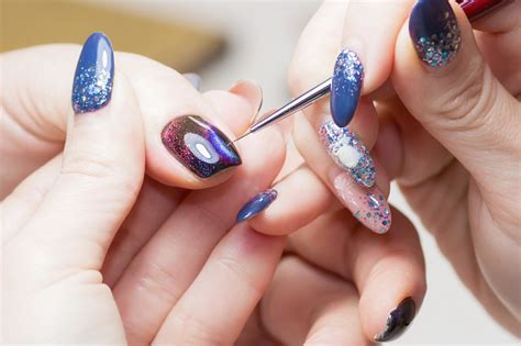 마스터는 보정 매니큐어 화려한 얼룩이있는 어두운 색 매니큐어 근접 촬영 사진을 수행합니다 간단한 배경에 여자의 손입니다 남성상에 대한 스톡 사진 및 기타 이미지 Istock