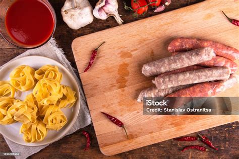 소시지 스튜와 미국 파스타 요리 테이블에 재료 소시지 으깬 토마토 마늘과 고추 페투치네 파스타 최고 전망의 두 가지 유형 고급 요리에 대한 스톡 사진 및 기타 이미지