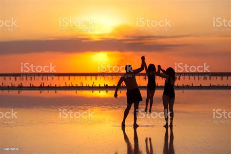 행복한 가족의 날 활동적인 엄마와 아빠의 실루엣은 손으로 어린 딸을 들어 올리고 여름 여행 휴가에 일몰에 바닷가에서 함께 즐거운 시간을 보내고 있다 세계 어린이날 30 34