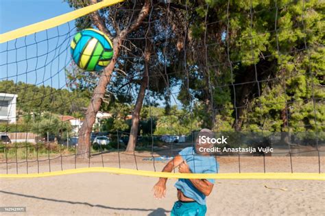 햇빛 아래에서 공을 가지고 행동하는 성숙한 비치 발리볼 선수 건강한 생활방식에 대한 스톡 사진 및 기타 이미지 건강한 생활