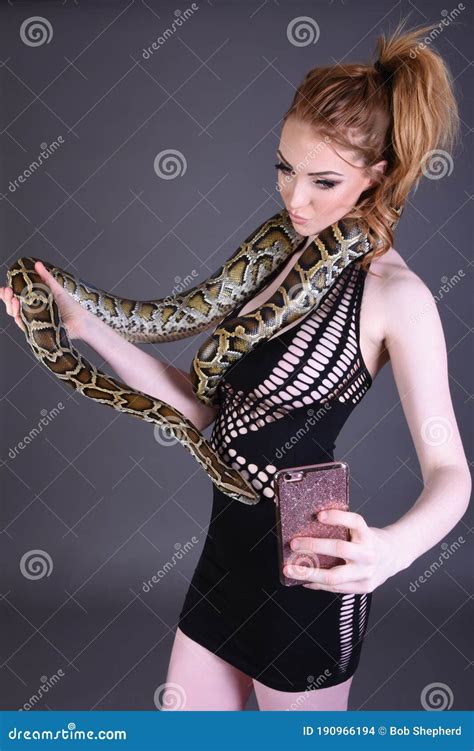 Beautiful Tall Slim Busty Redhead Model In A Sexy Black Mesh Dress Posing With A Snake